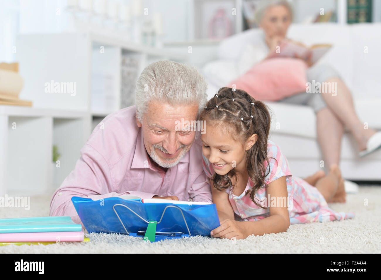 Grandfather reading book with his little granddaughter at home Stock ...