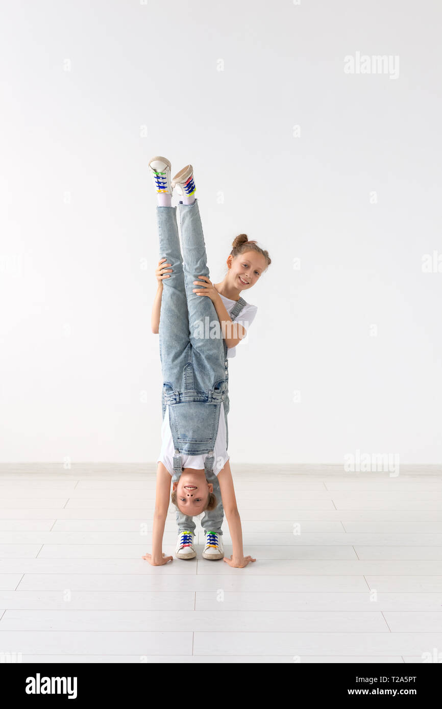 people, children and acrobatic concept - little twin sisters doing ...