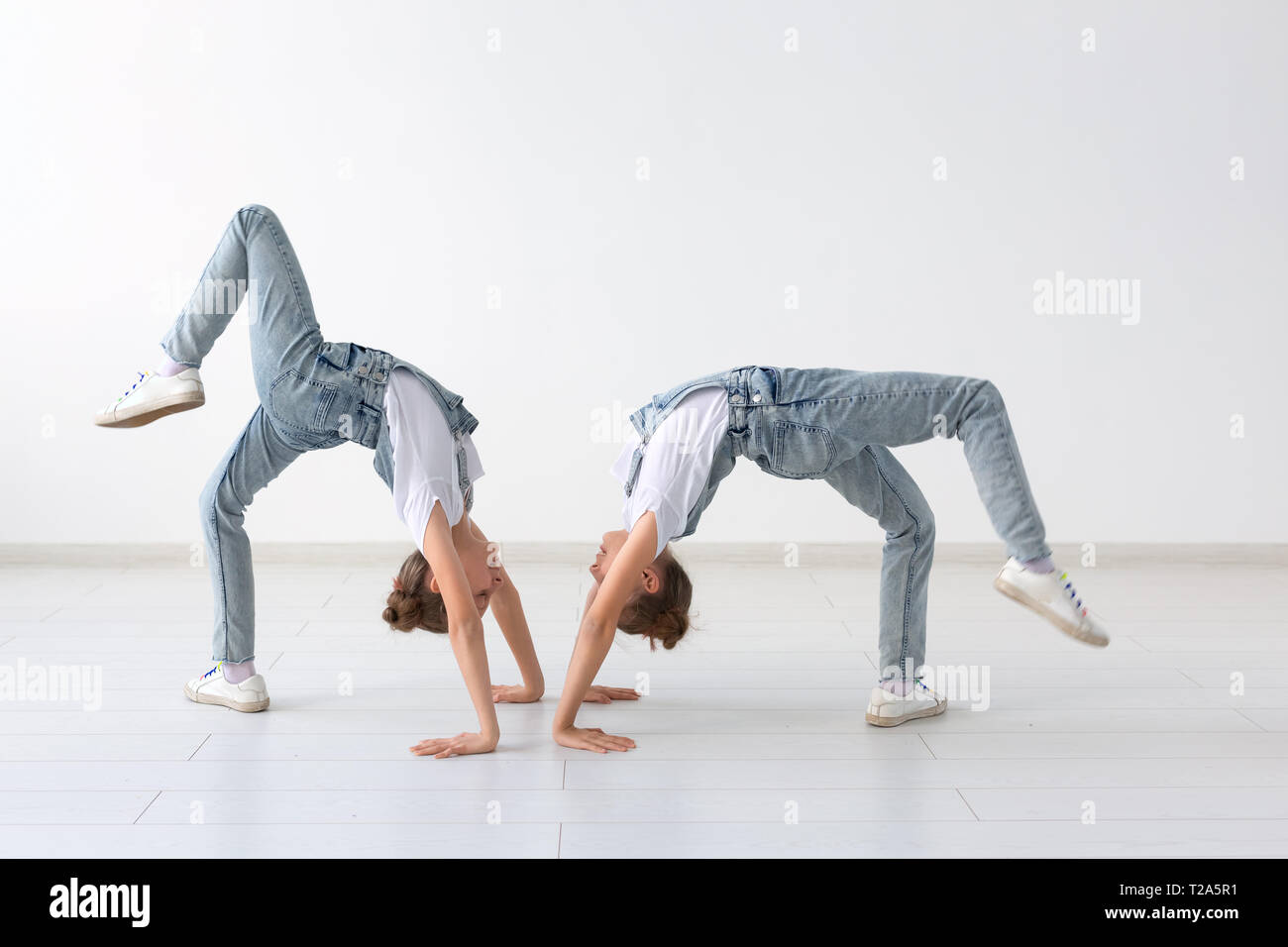 people, children and acrobatic concept - little twin sisters doing ...