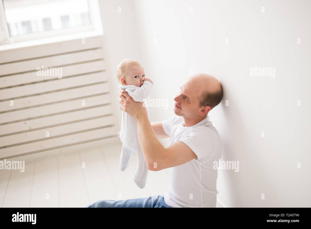 Parenting, family and fatherhood concept - Bald father sitting on the ...