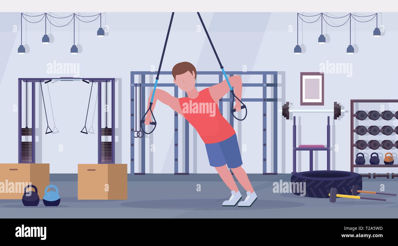 sporty man doing exercises with suspension fitness straps elastic rope ...