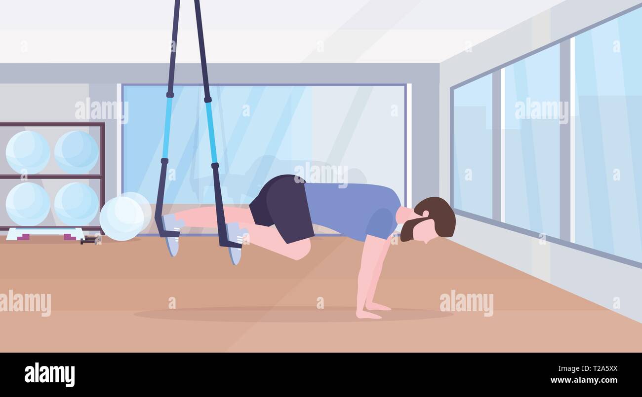 sporty man doing exercises with suspension fitness straps elastic rope ...