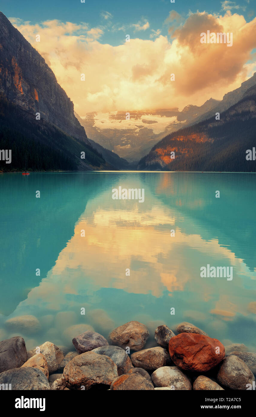 Lake Louise at sunrise with rocks in Banff national park with mountains ...