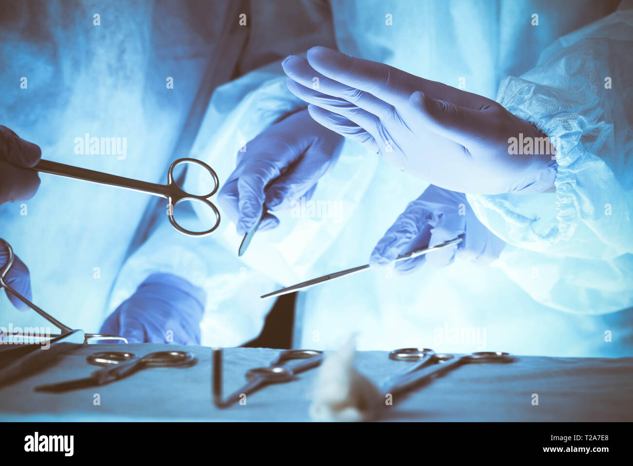 Surgeons hands holding surgical scissors and passing surgical equipment ...