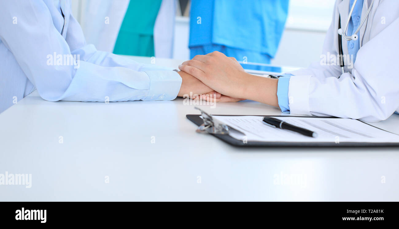 Hand of doctor reassuring her female patient. Medical ethics and trust ...