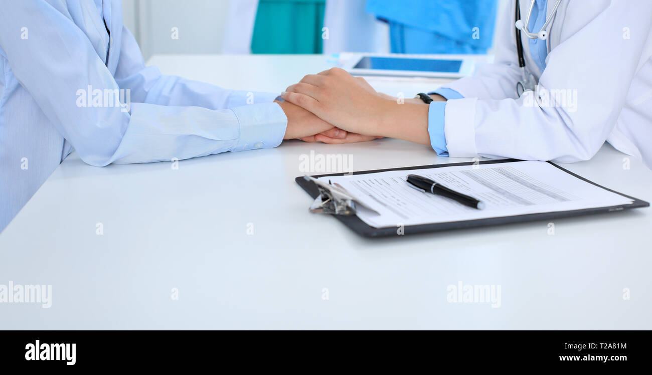 Hand of doctor reassuring her female patient. Medical ethics and trust ...