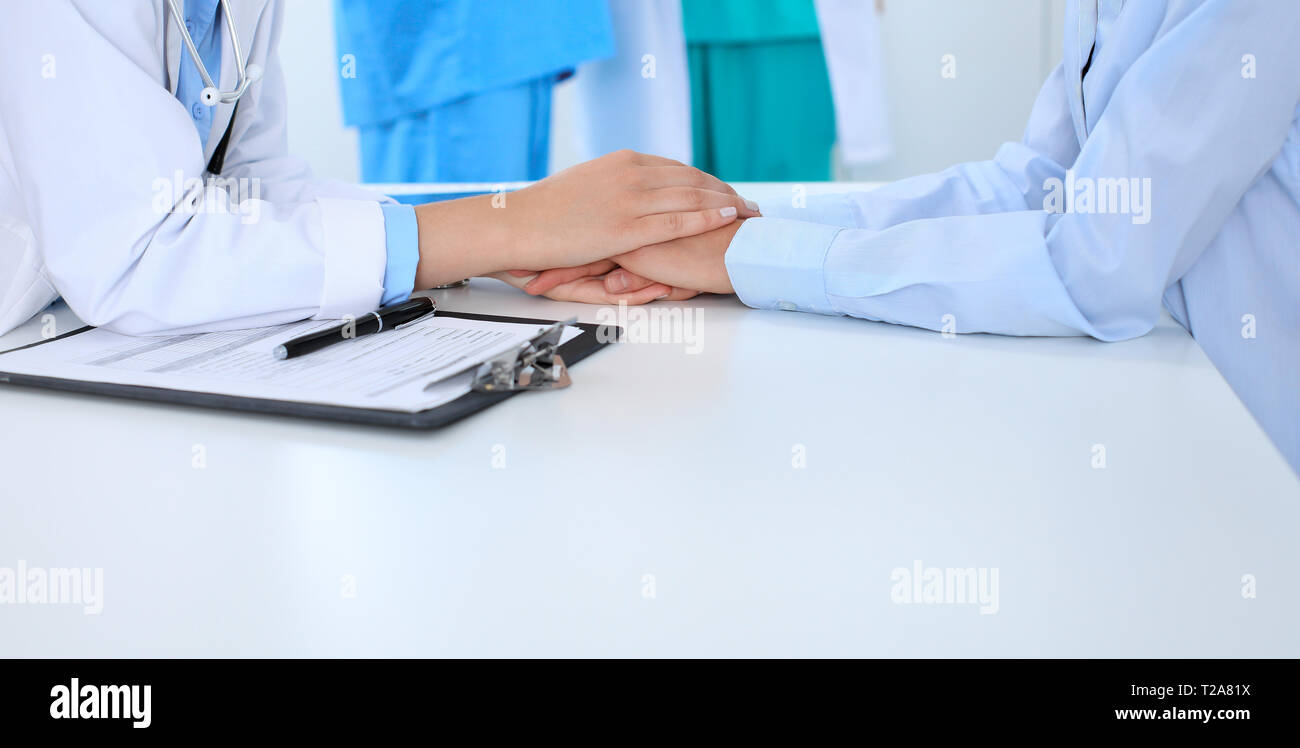 Hand of doctor reassuring her female patient. Medical ethics and trust ...