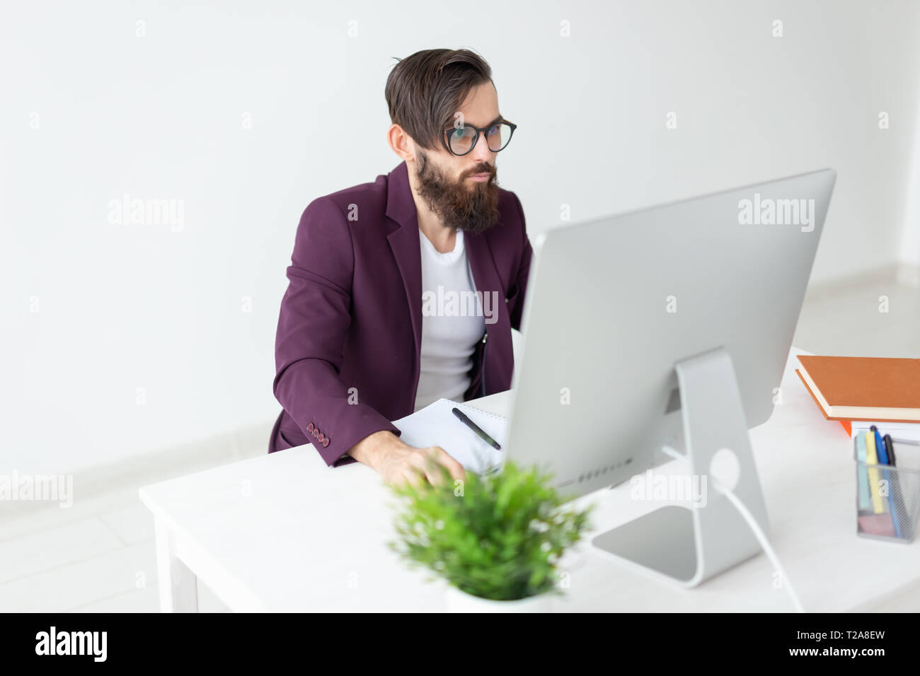 People and technology concept - Man sits and works at the computer ...