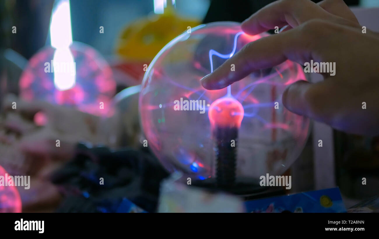 Woman hand touching plasma ball Stock Photo - Alamy