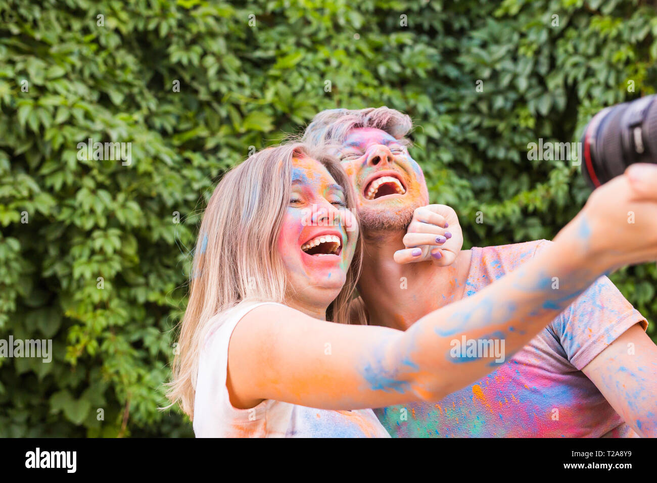 Holiday and people concept - Woman and man with painted faces taking ...