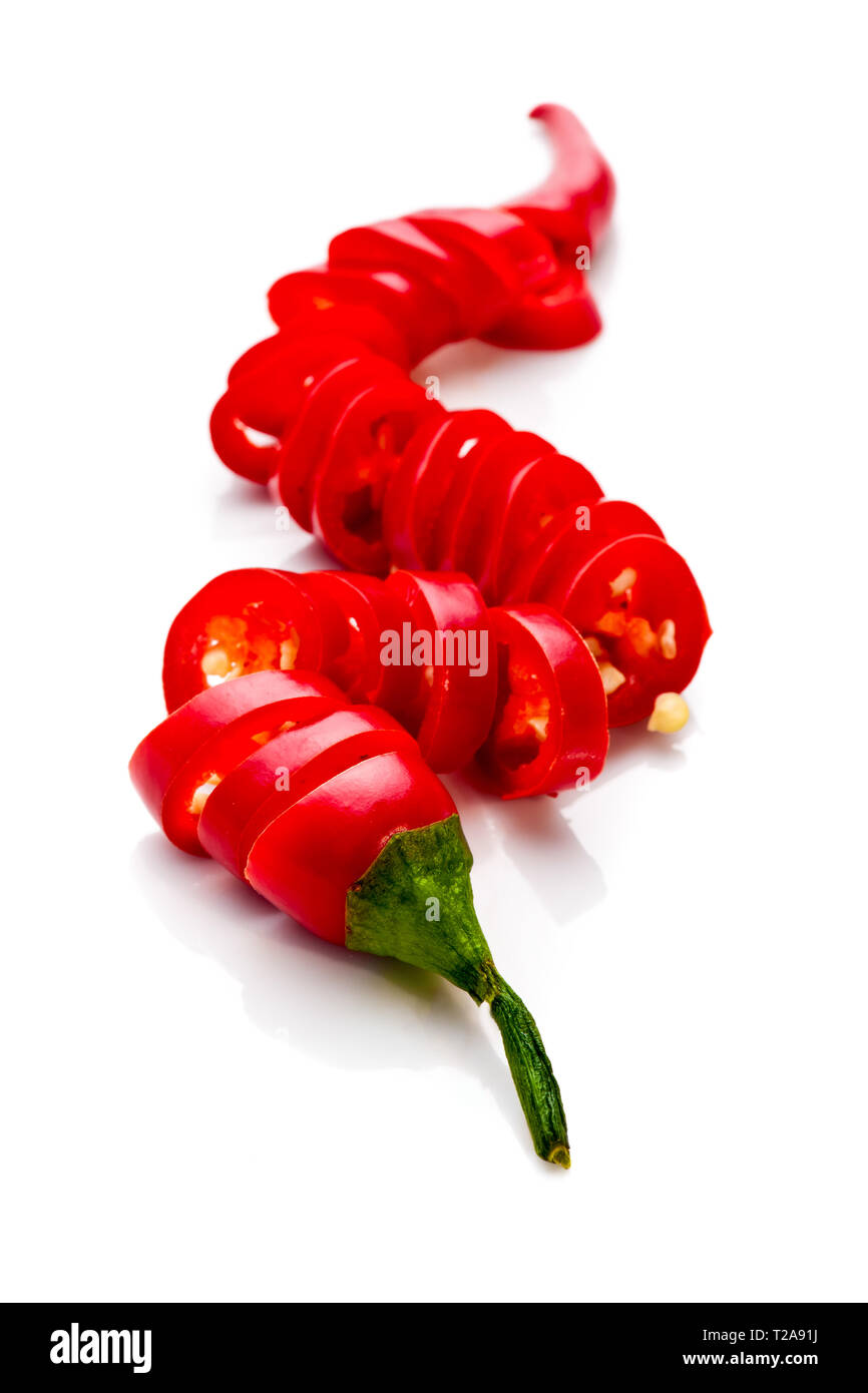 studio photo of a red pepper cut into small slices, lying on a white ...