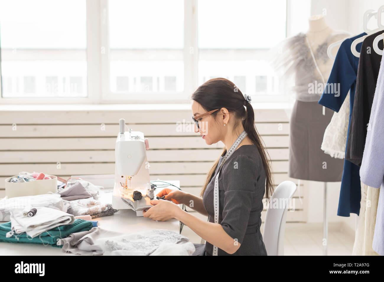 people, dressmaker, tailor and fashion concept - young fashion designer ...