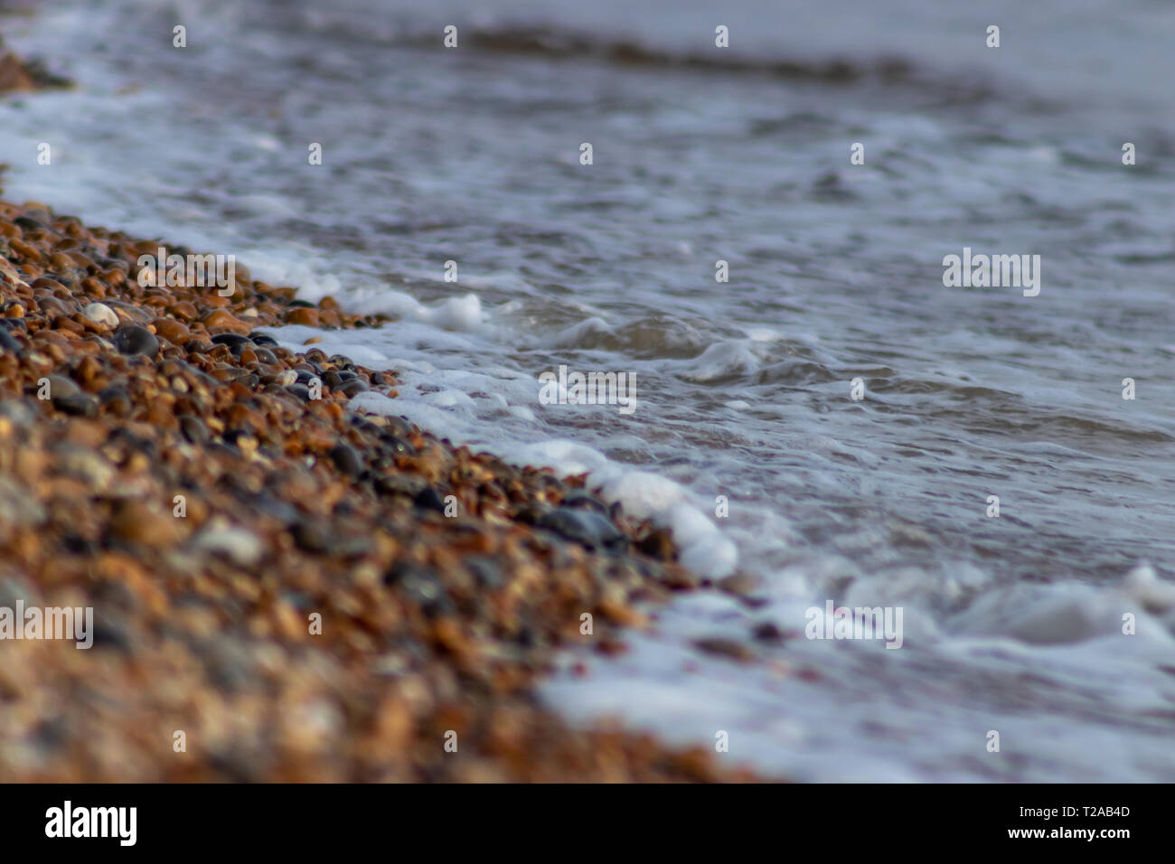 Sea water meeting stones of Brighton beach Stock Photo - Alamy
