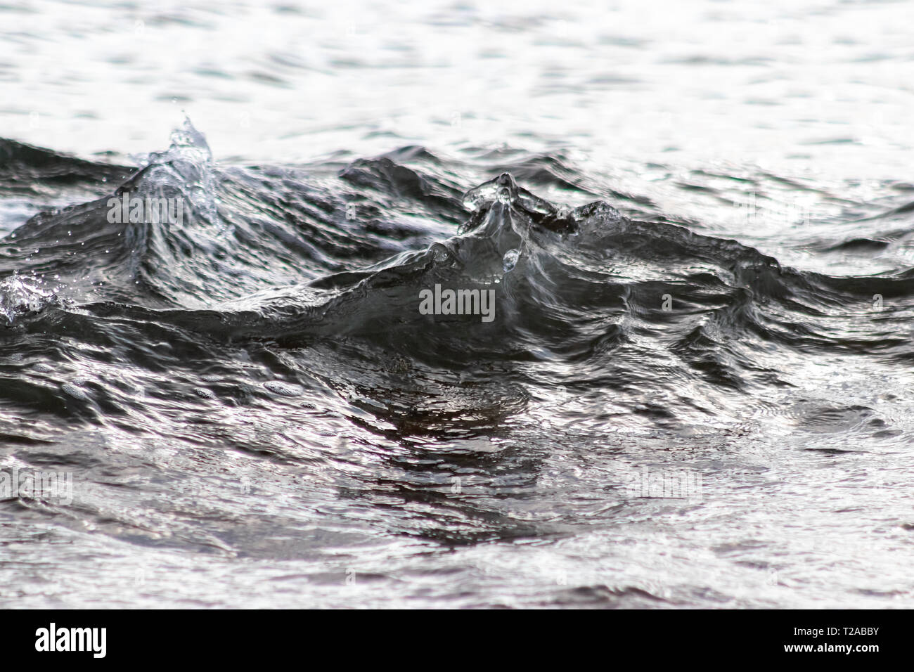 Small ocean waves breaking on a stoney beach Stock Photo - Alamy