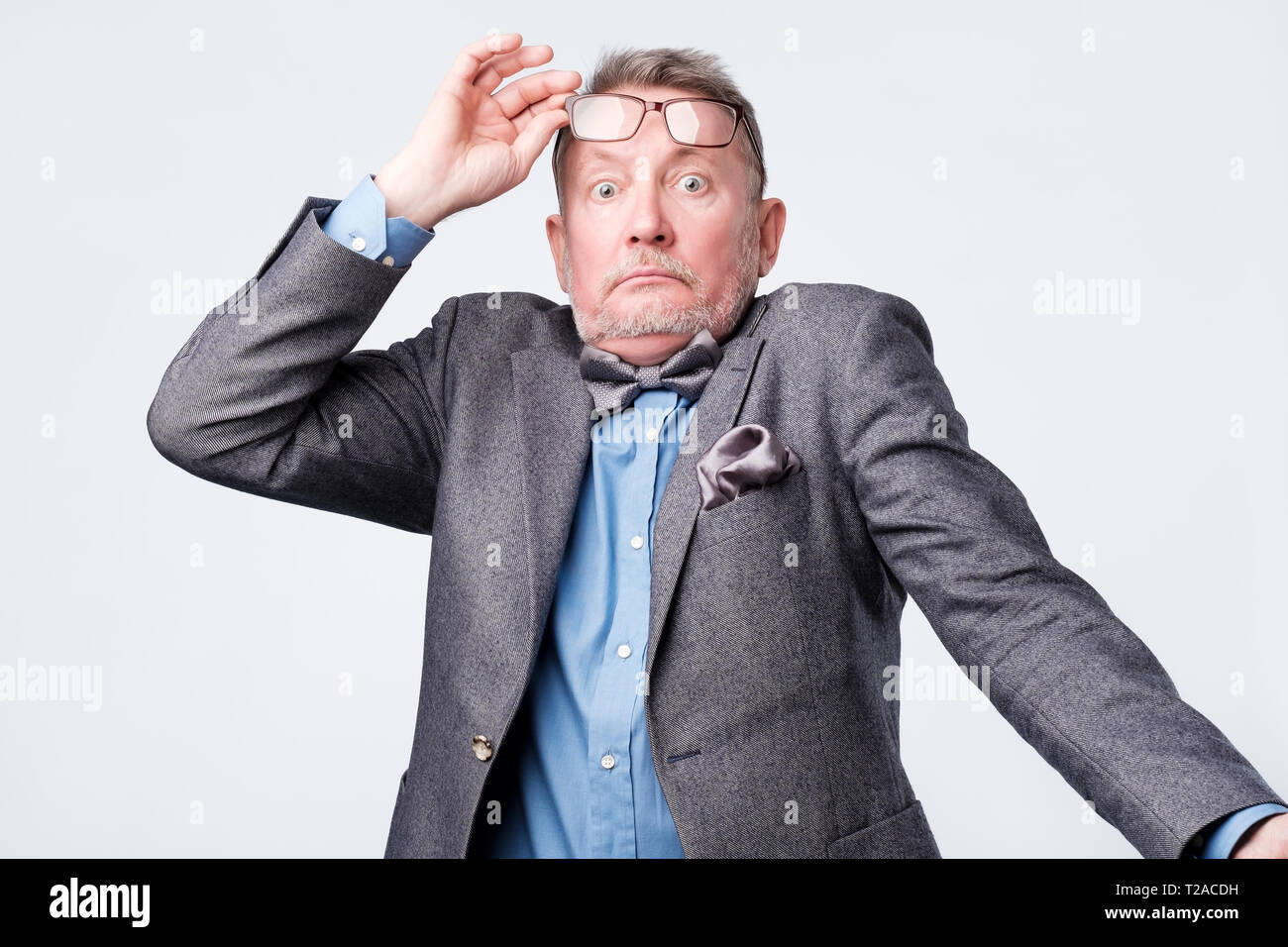 Doubtful senior man with glasses is unsure and upset. Studio shoot ...