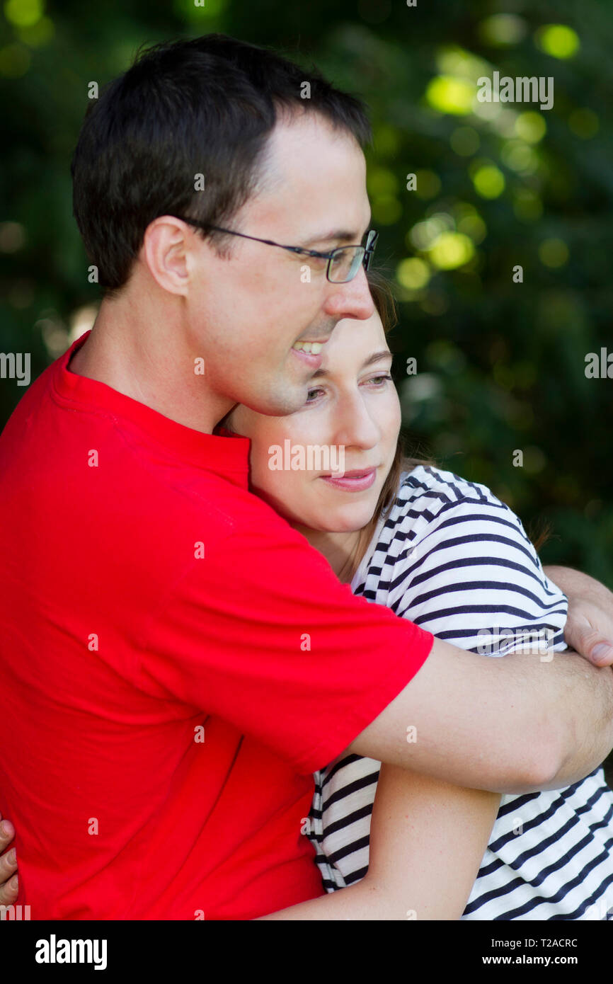 Man in red shirt hugging wife Stock Photo - Alamy