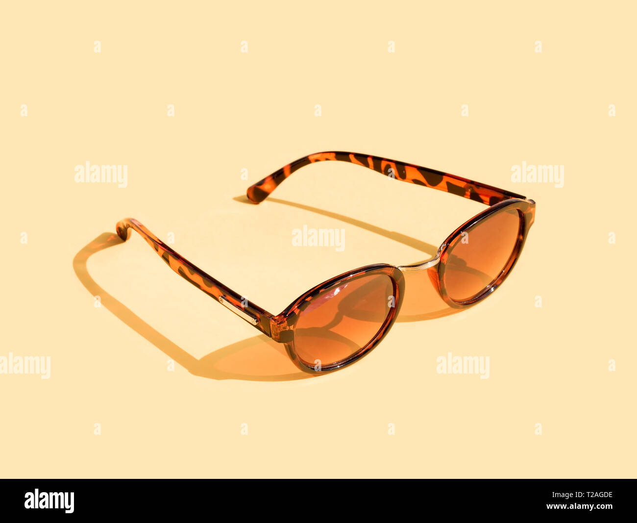 Sunglasses on yellow background with the shadow Stock Photo - Alamy