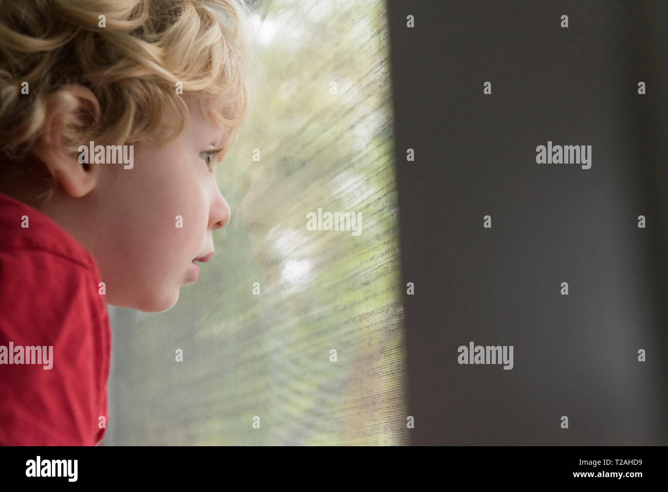Boy looking out window Stock Photo - Alamy