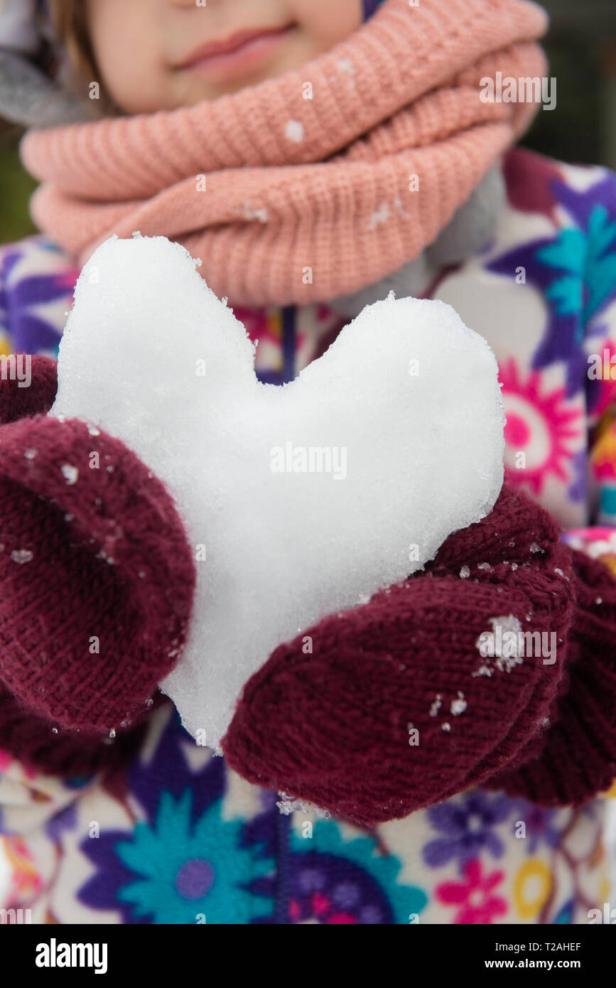 Hands of girl holding snow heart Stock Photo - Alamy