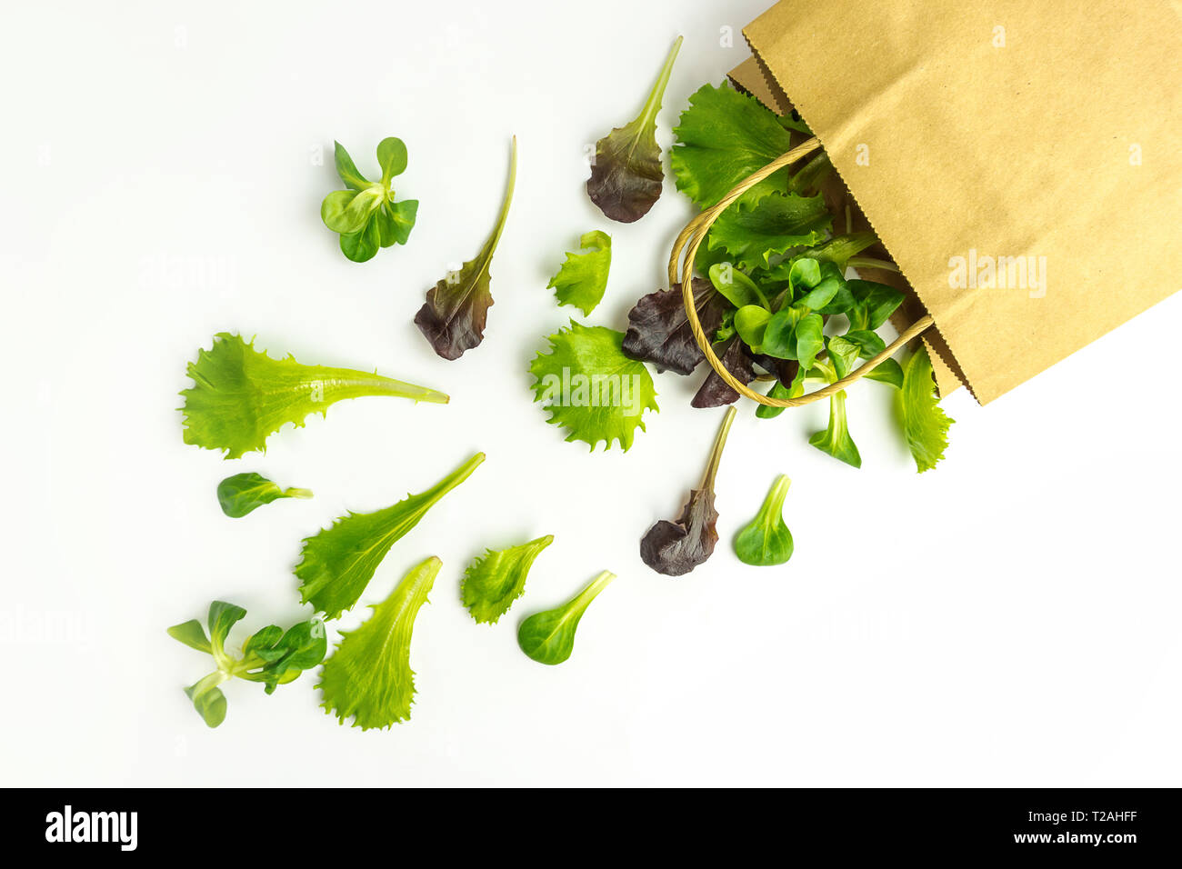 Paper bag spill green leafy vegetables salad on white background Stock ...