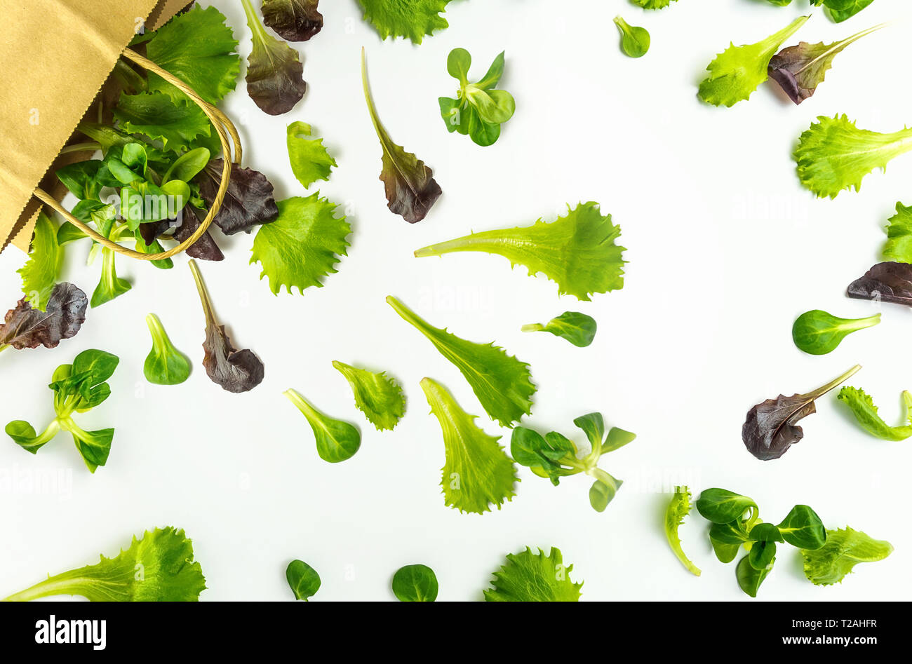 Paper bag spill green leafy vegetables salad on white background Stock ...