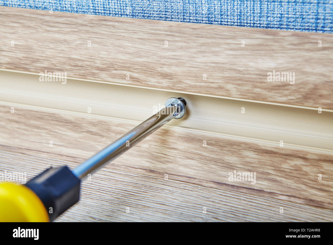 Twisting PVC plinth in cable channel with screw with help of ...