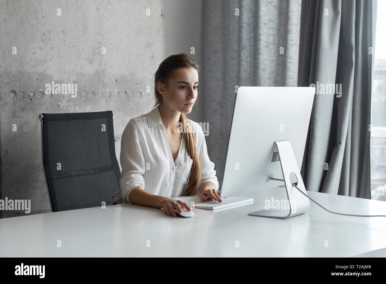 Young woman working on desktop hi-res stock photography and images - Alamy