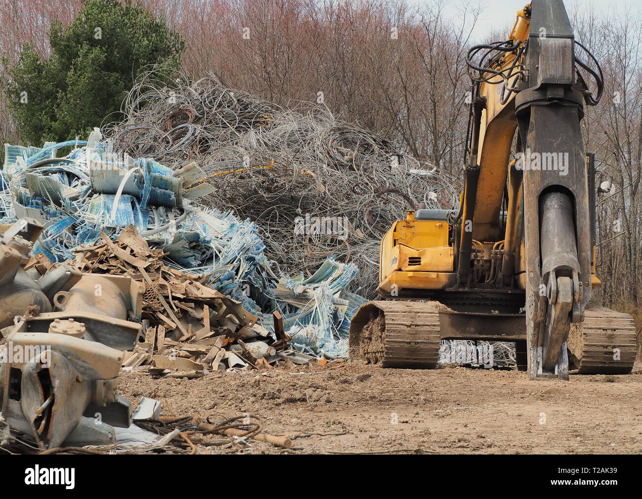 Scrap Yard metal shear mounted on excavator with pile of fiberglass ...