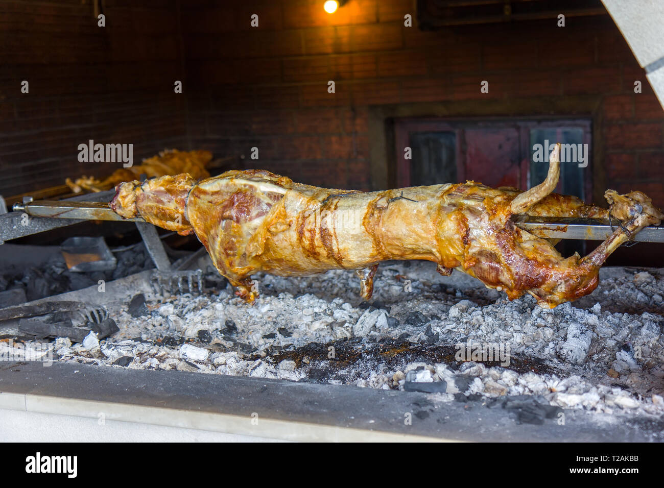 Lamb being roasted whole on a spit Stock Photo - Alamy