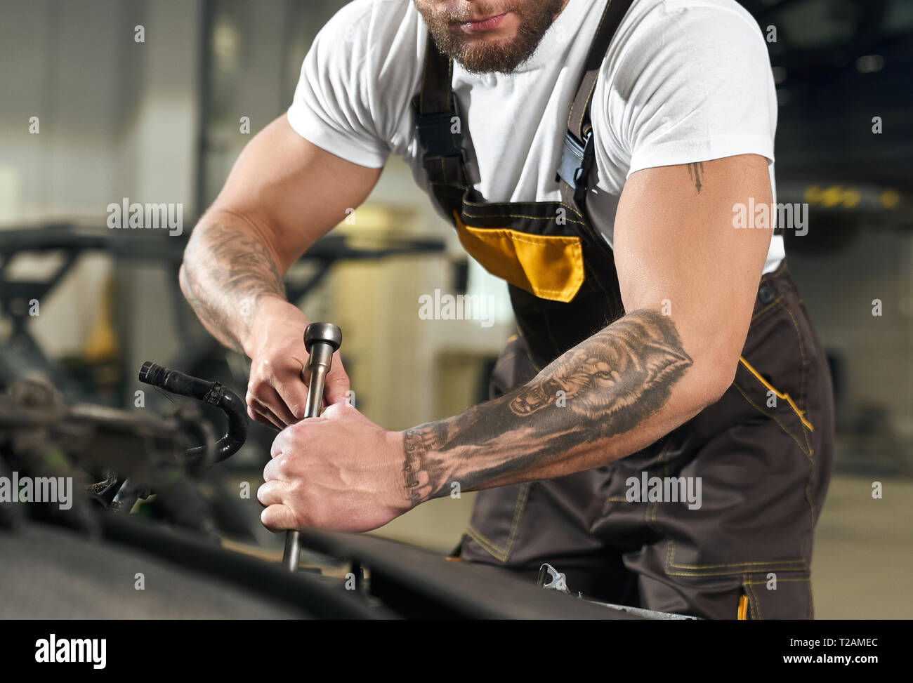 Side view of male mechanic with strong muscular hands and tattoo ...
