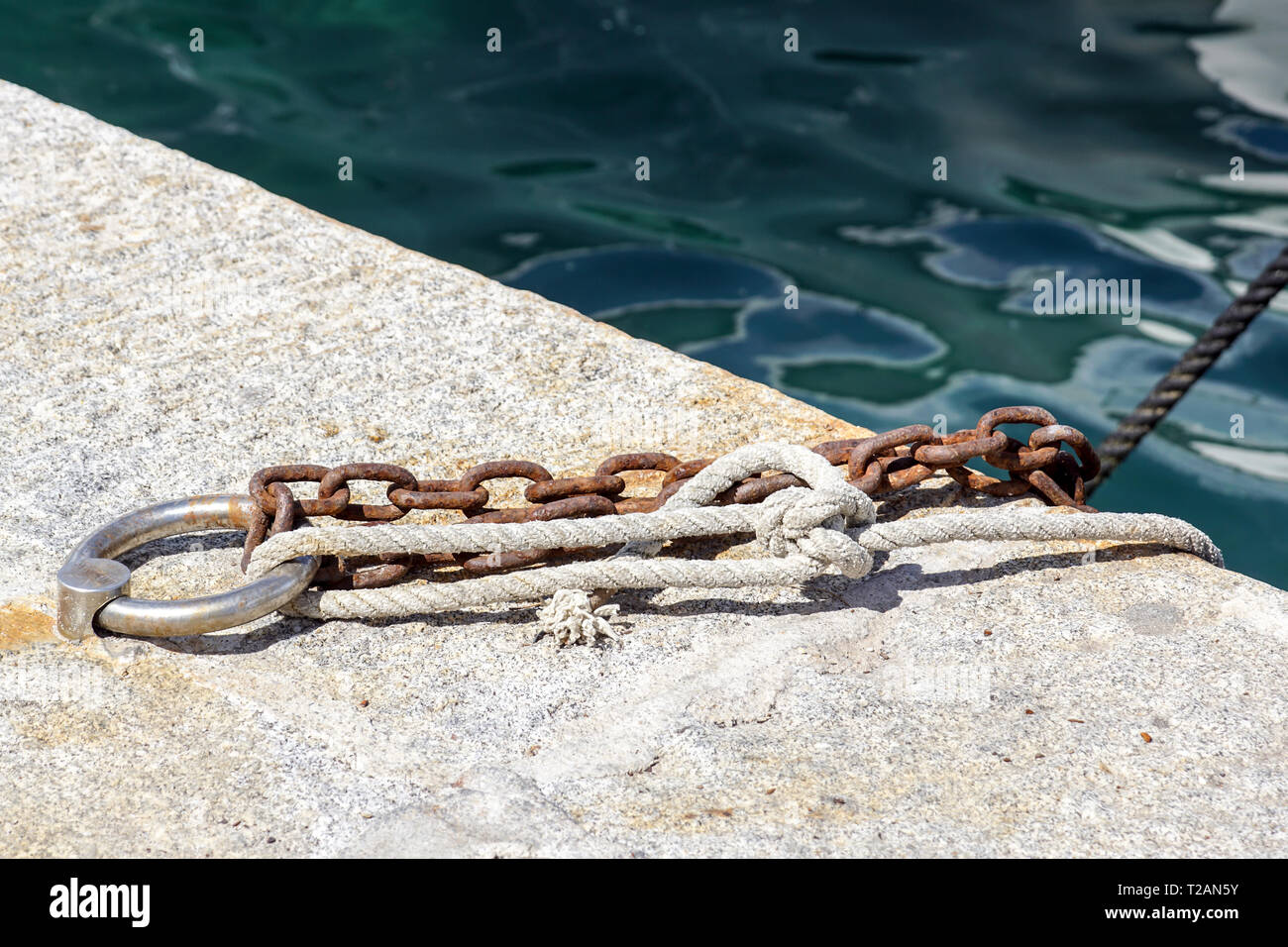 Old metal rusty mooring bollard with a chain wrapped around Stock Photo ...
