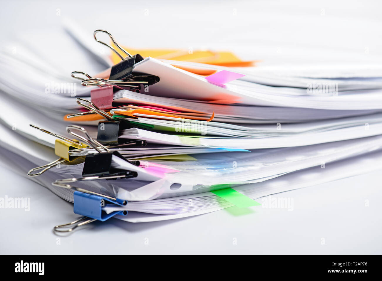 Pile various documents, reports and receipt with colorful paperclip on ...
