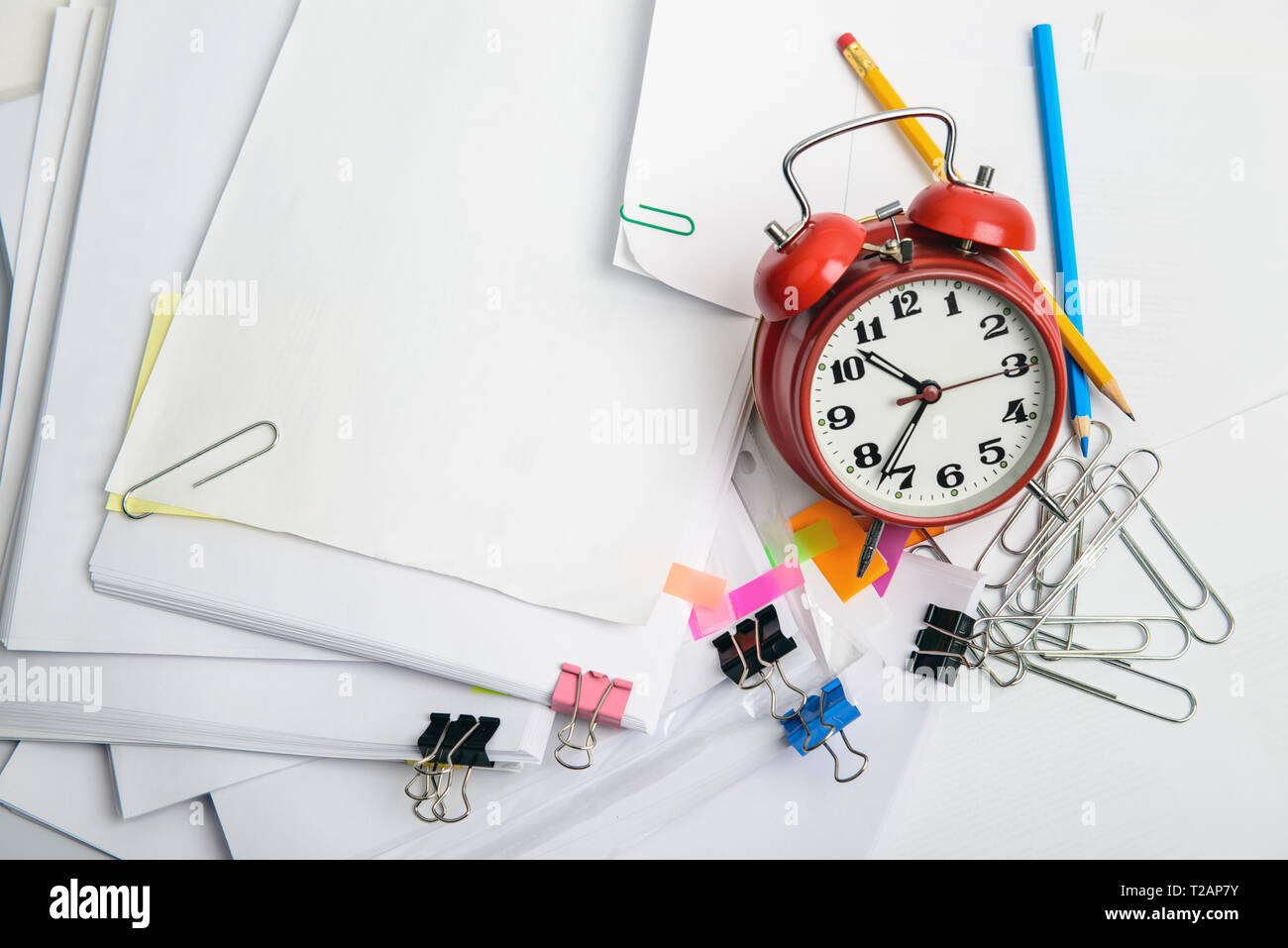 Alarm clock, over pile various documents, reports and receipt with ...