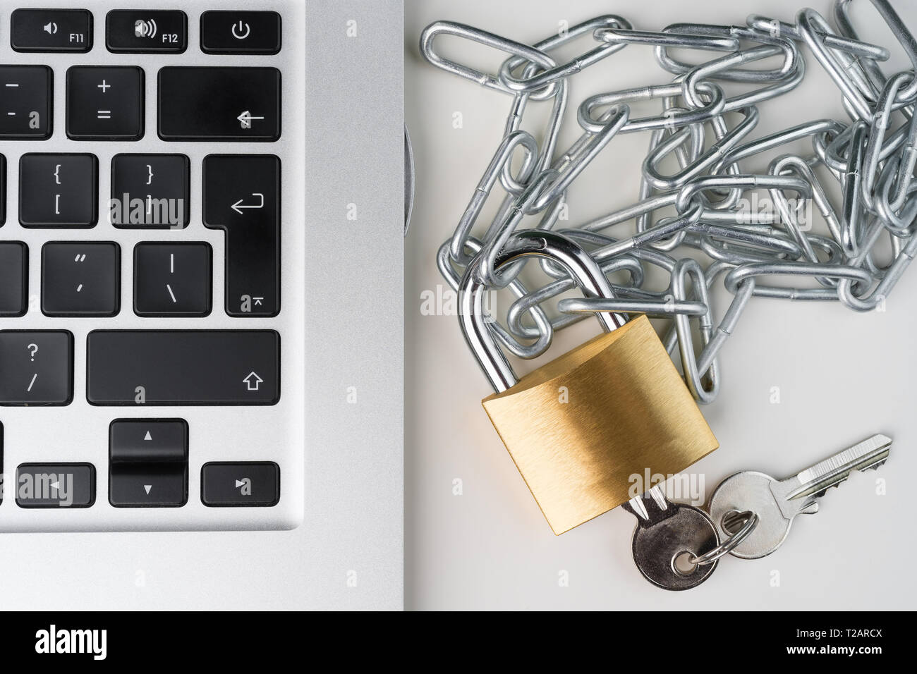 Padlock, chain and keys with laptop computer on a white background. Cyber security abstract ...