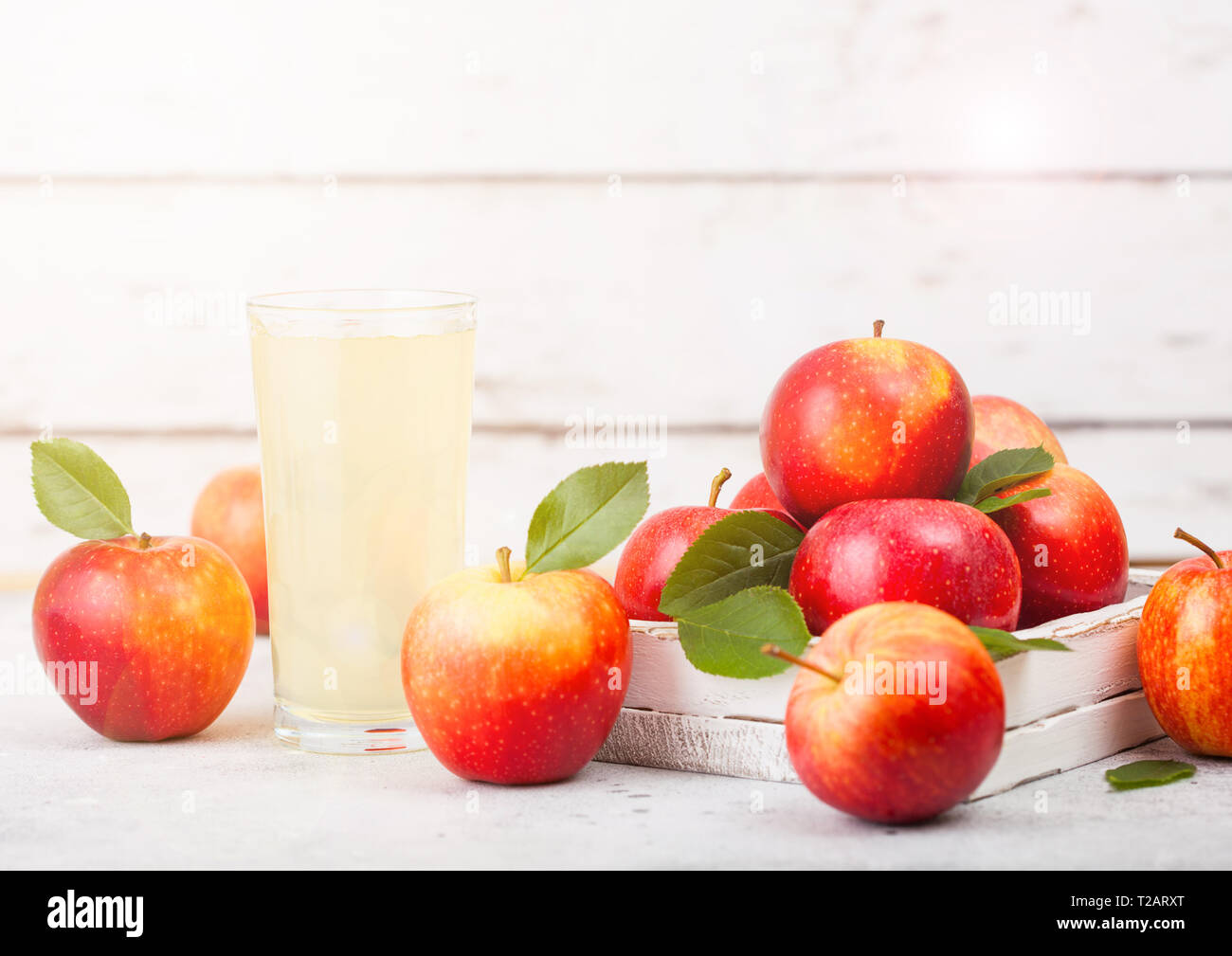 Glass of fresh organic apple juice with braeburn pink lady apples in ...