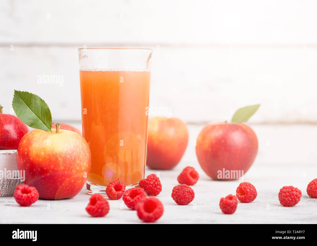 Glass of fresh organic apple and raspberry juice with fresh fruits in ...