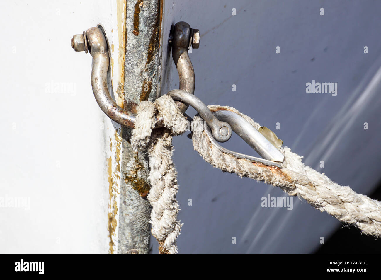 Steel rope and rusty hook on the back side of the sailing boat. Flag of ...