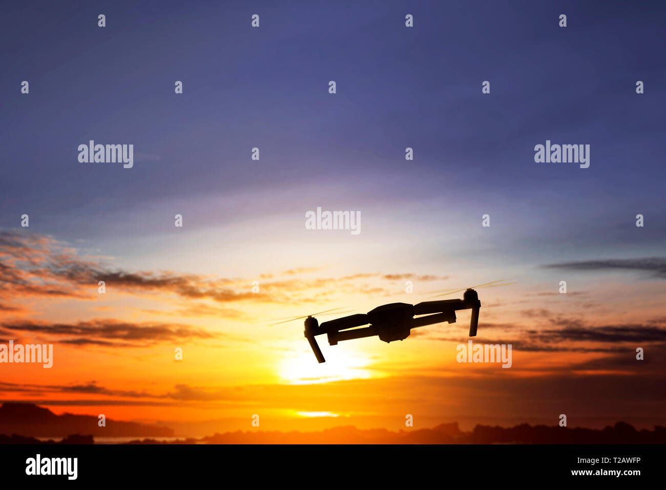 Silhouette of drone with camera flying over sunset view background Stock Photo - Alamy