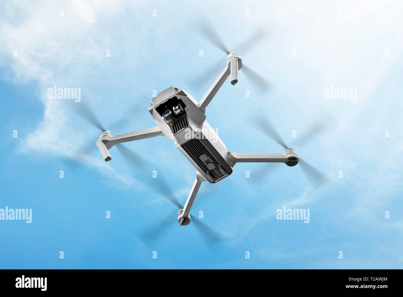 White drone with camera flying in the air over blue sky background ...