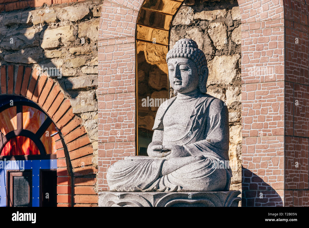 White stone statue of a Buddha on masonry background Stock Photo - Alamy