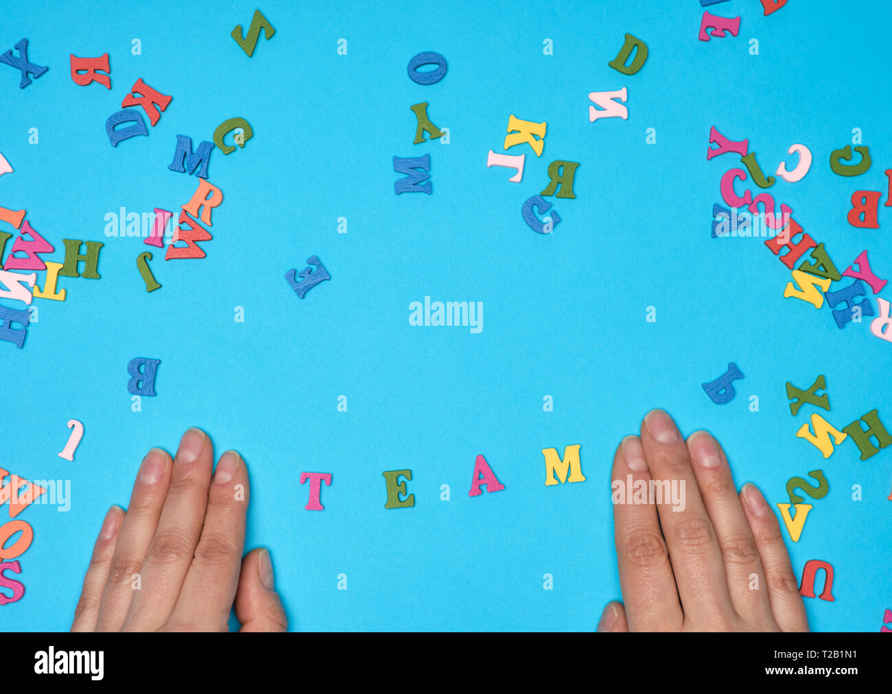 multicolored wooden letters of the English alphabet on a blue ...