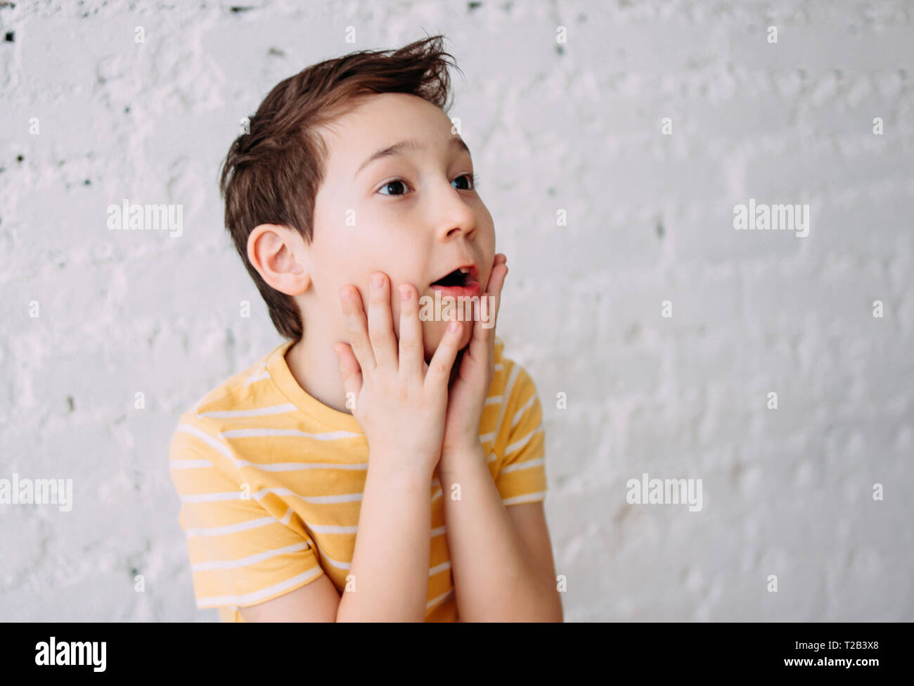 Cute tween surprised boy with funny face in yellow t-shirt isolated on ...