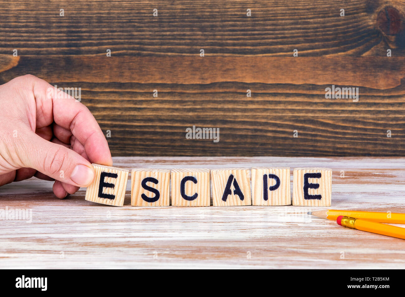 Escape. Wooden letters on the office desk, informative and ...