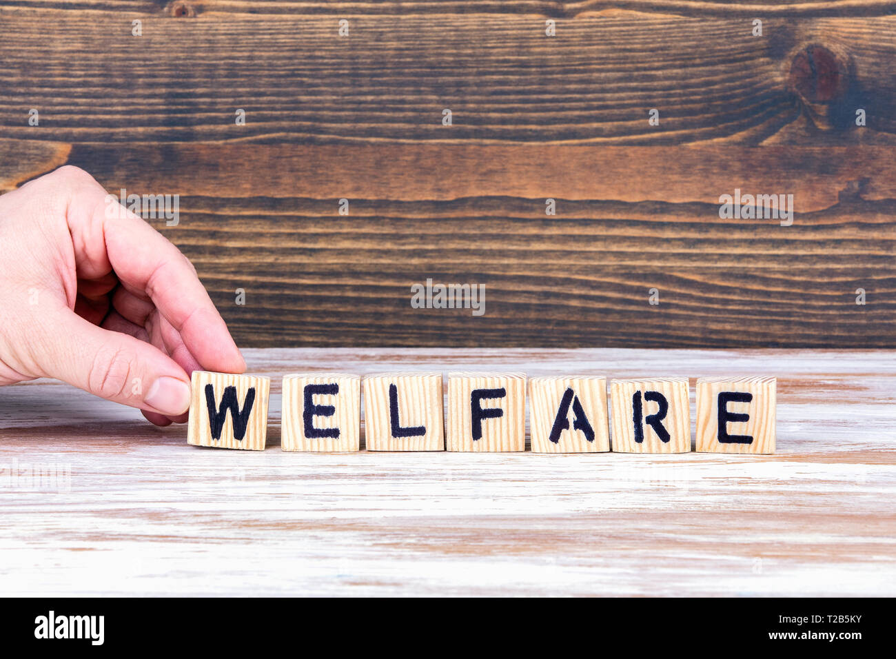 Welfare. Wooden letters on the office desk, informative and ...