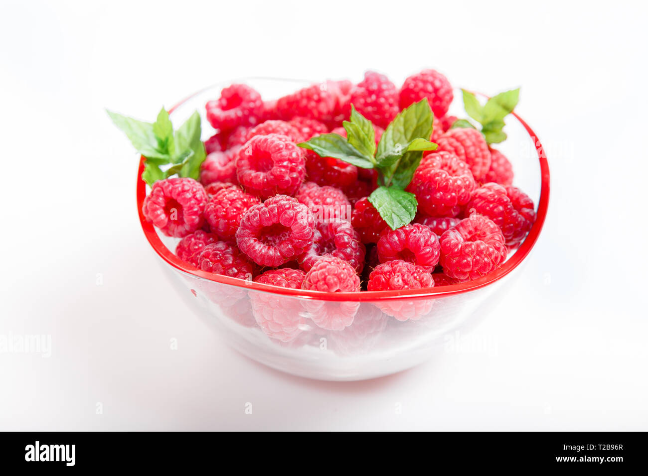 Ripe sweet raspberries in bowl on white. Close up, top view, high ...