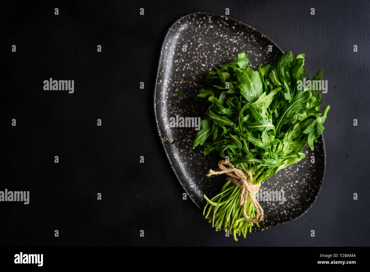 Organic rocket herb on stone plate as a healthy food concept Stock ...