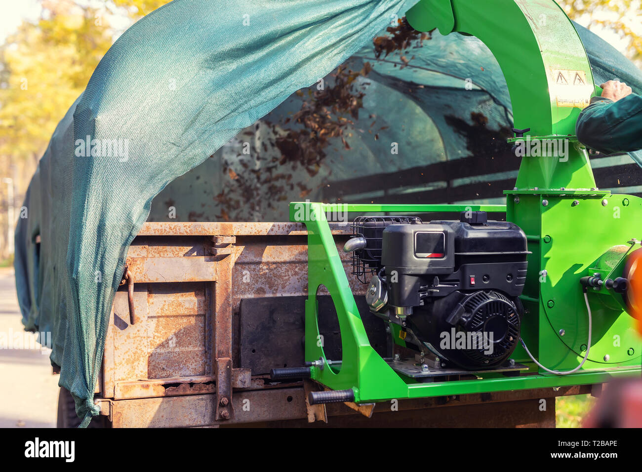 Heavy industrial vaccuum loader loading fallen leaves and junk into ...