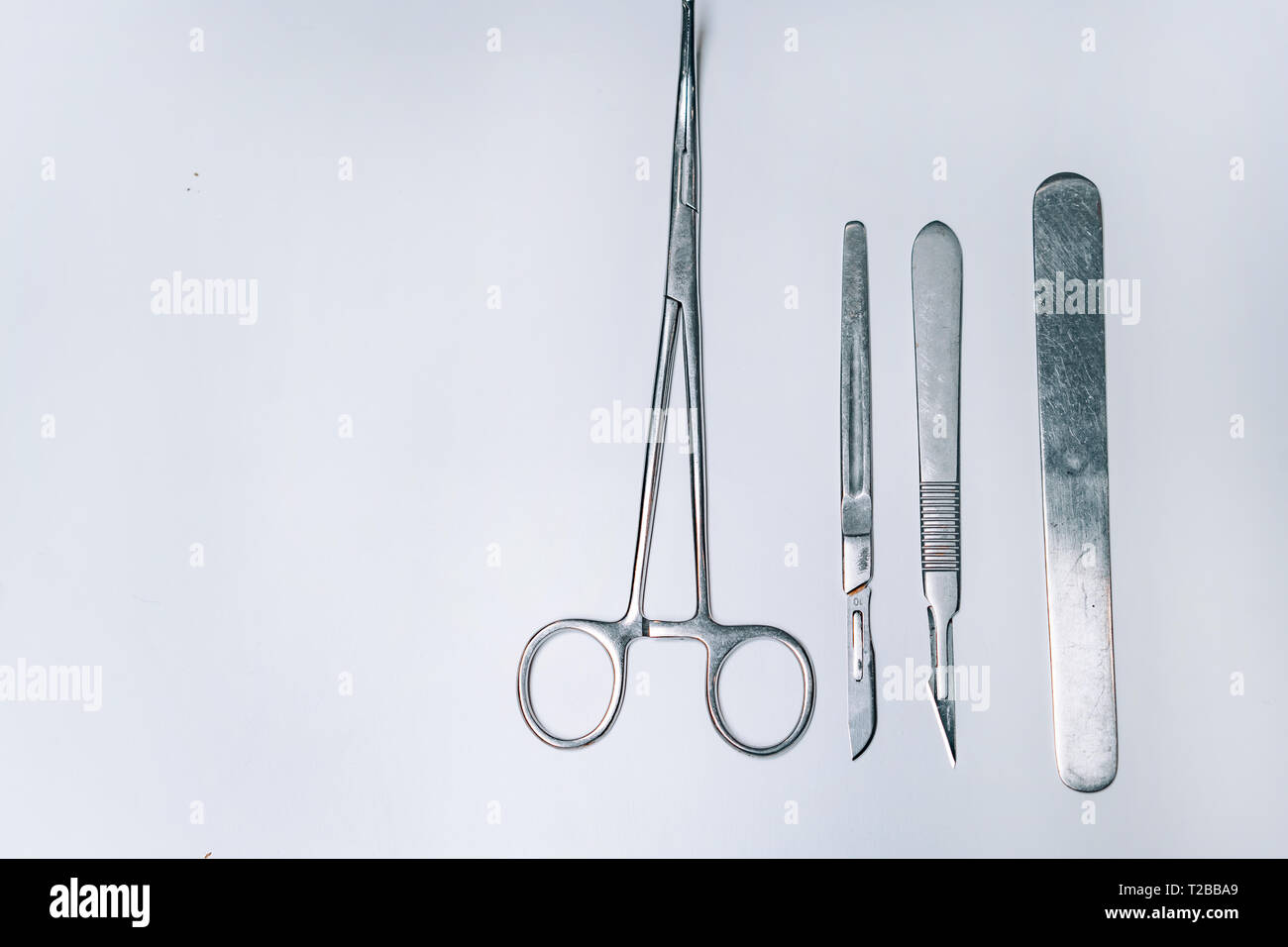 Scapula for throat, two scalpels and clamp on a light background, close ...