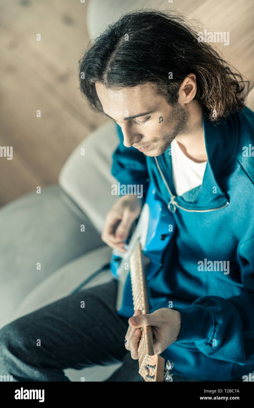 Thoughtful good-looking guitarist playing his musical instrument Stock ...