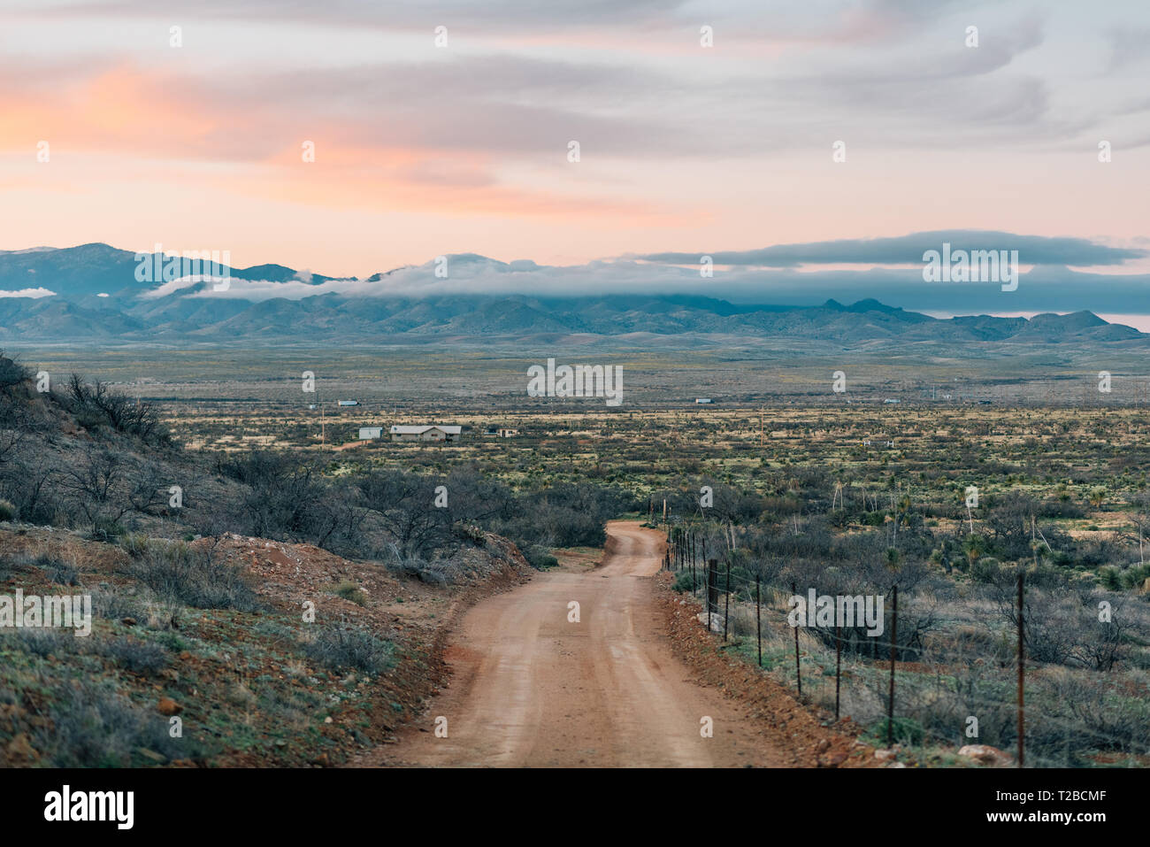 Dirt road and mountains at sunset in the desert of eastern Arizona ...